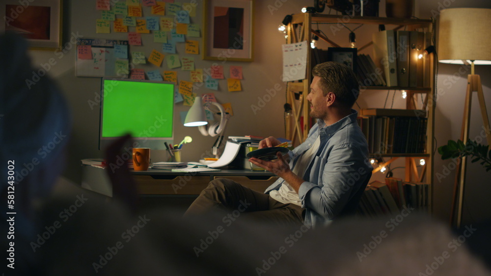 Relaxed person speaking green screen computer at home. Man eating ...