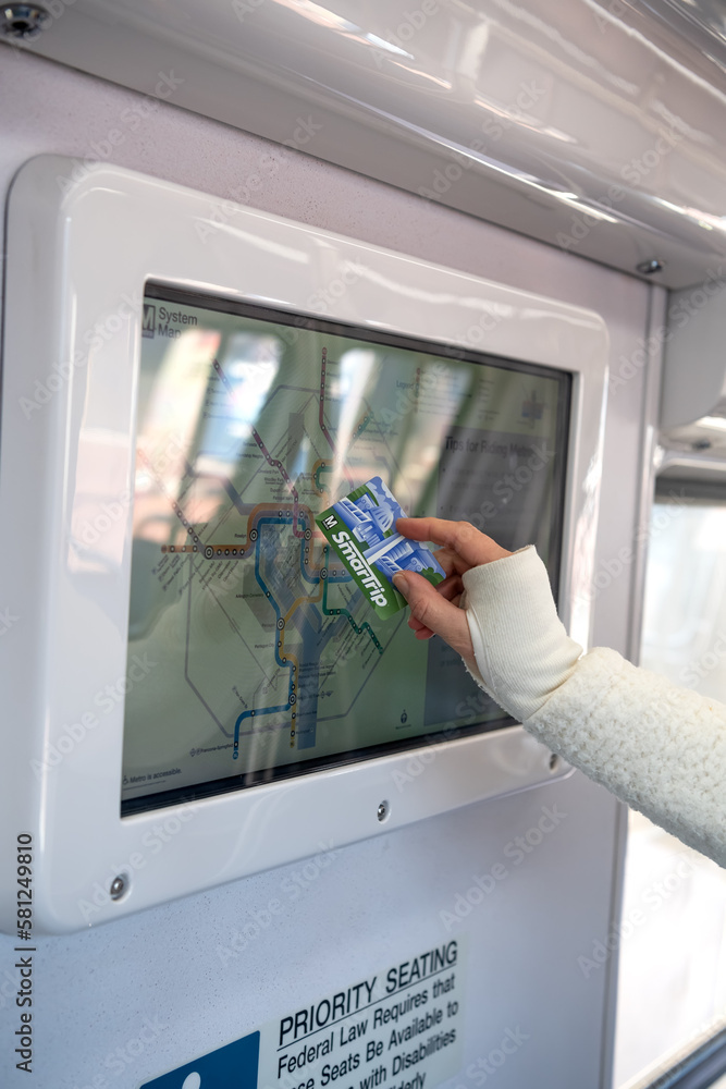 woman holds a SmarTrip subway map and studies the subway map while on a ...
