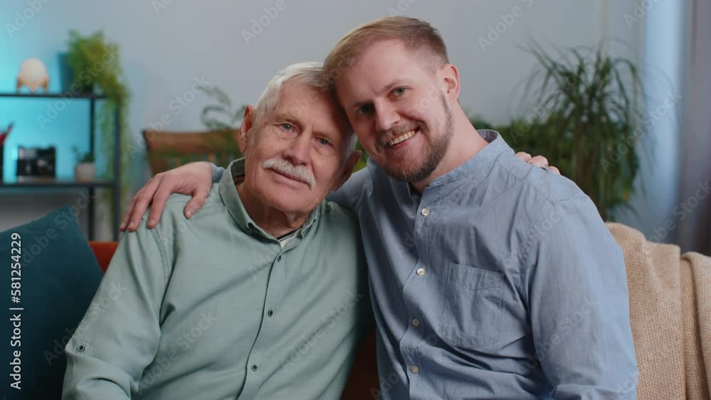 Portrait of senior grandfather with young adult man grandson smiling ...