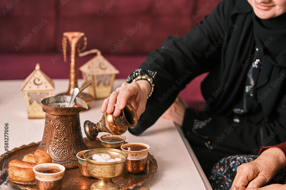 Happy Muslim family woman in hijab serving Turkish coffee to her old ...