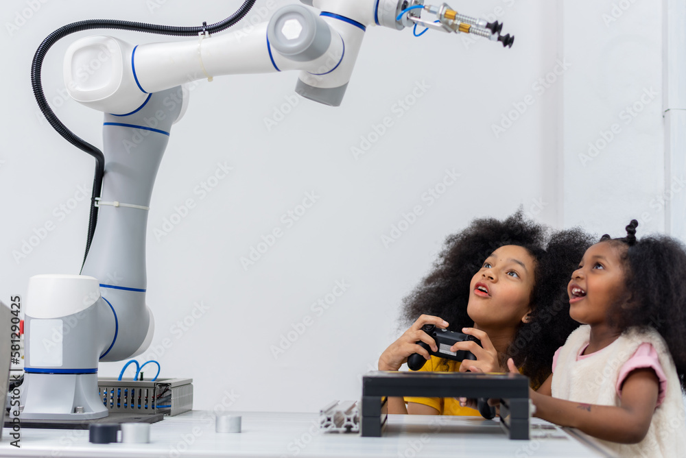 Kid female teen child enjoy Machine Learning Robot arm is Moving Under ...