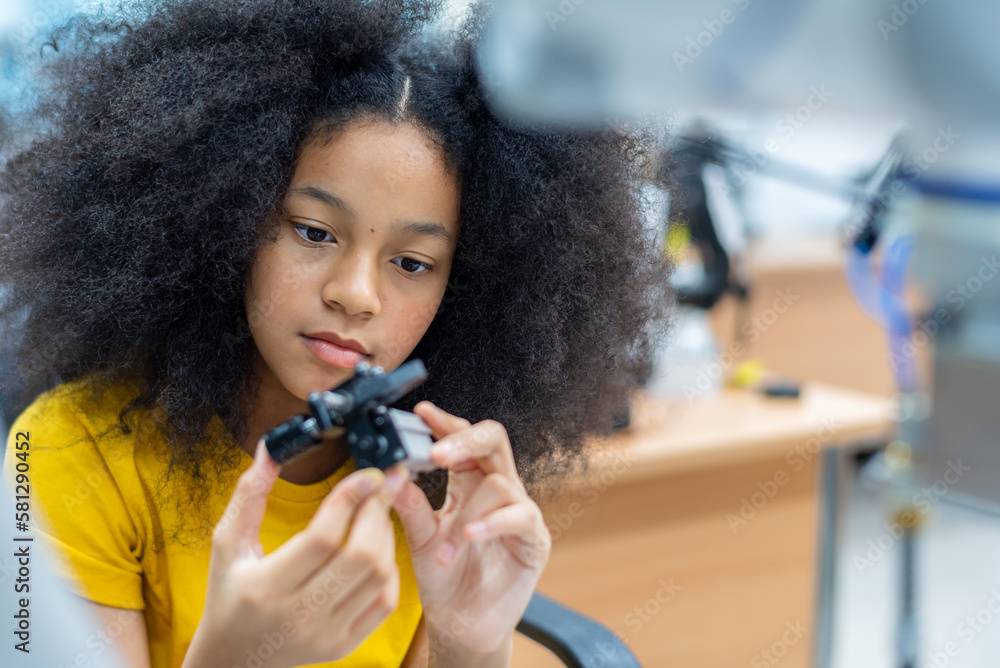 Girl female teen children concentrate enjoy Machine Learning Robot is Moving Under Control robot ...