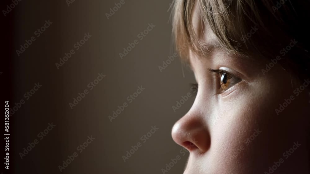 Tired eyes of 6 year boy looking at screen close-up. Child is watching ...