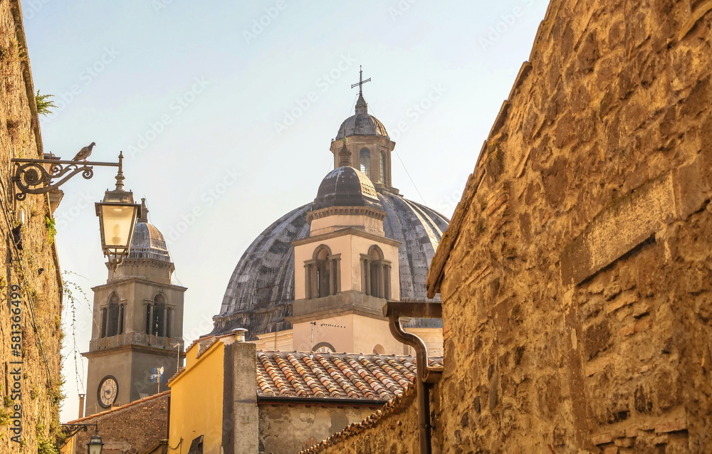 A street of a medieval Italian town with tiled roofs, lanterns and a ...