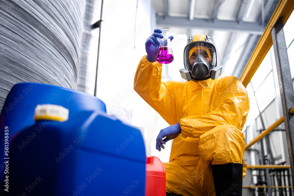 Chemical factory worker wearing protection suit and gas mask testing ...