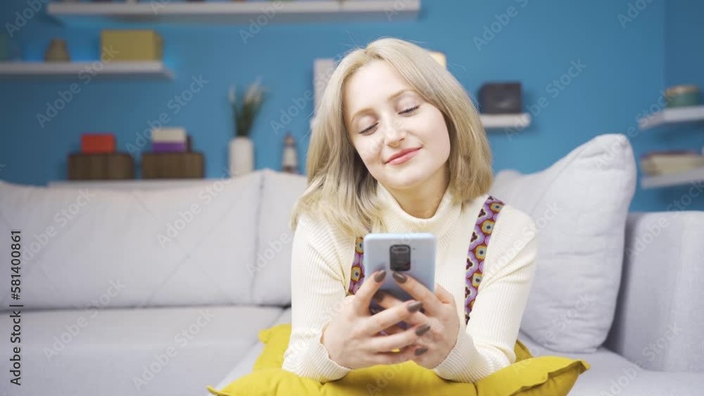Young blonde woman texting on the phone while lying down. The blonde ...