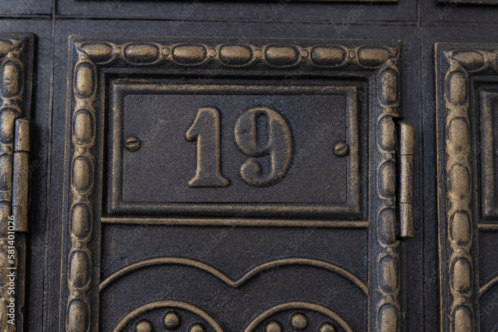 Number 19 on metal door. Old vintage retro copper plate with the number ...