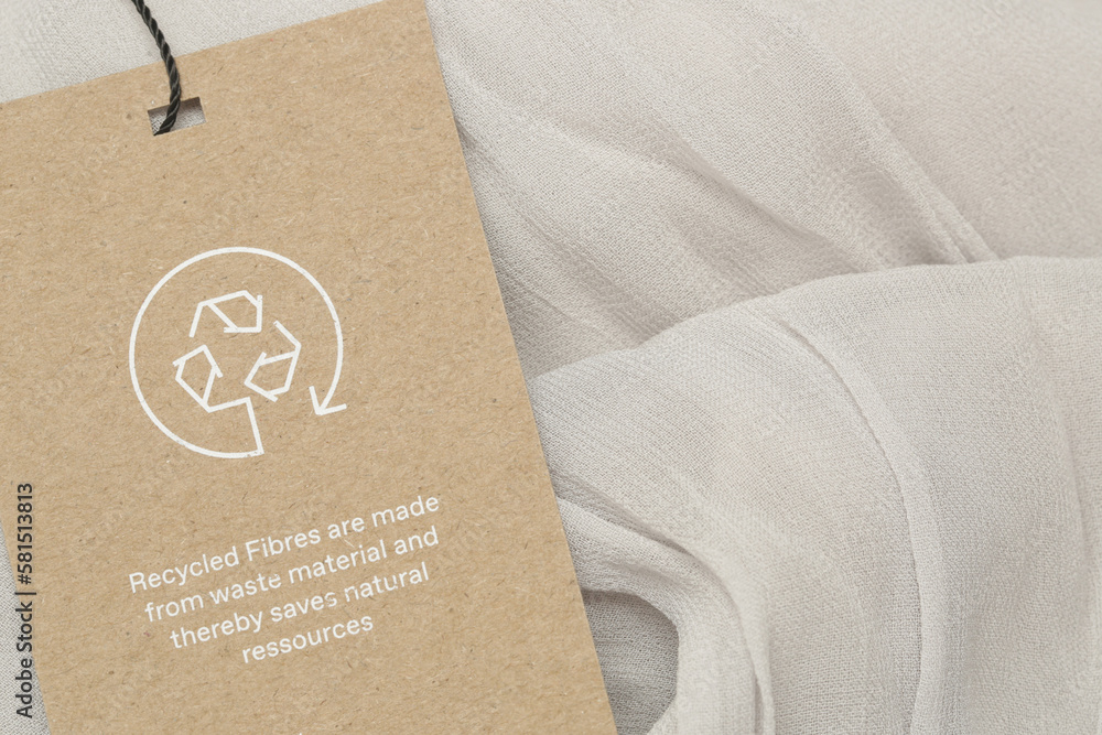 Close up of clothing tag with recycle icon. Recycling products concept ...