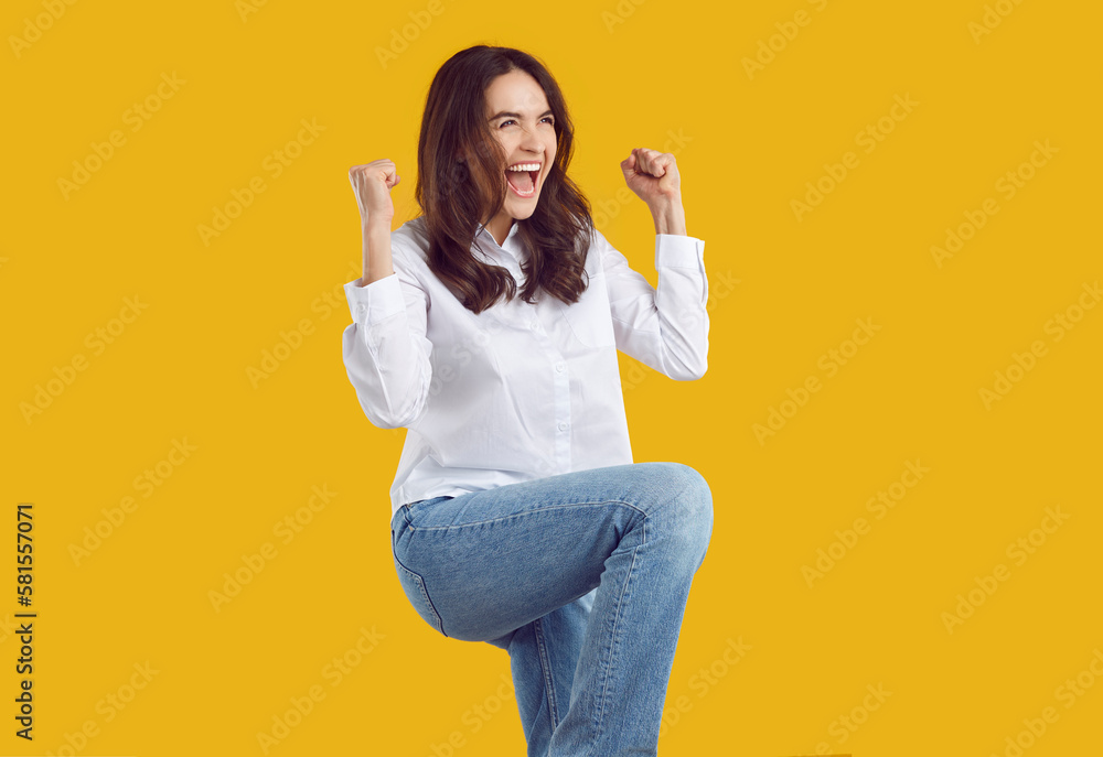 Portrait of excited young woman clenching fists doing winner gesture ...