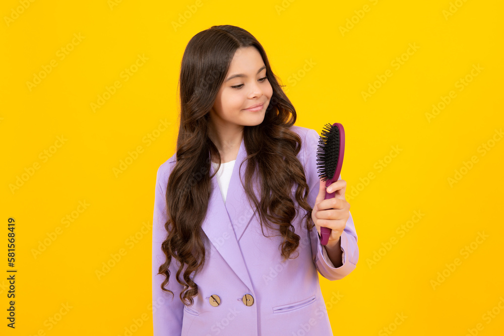 Child brushing combing hair with big comb on yellow isolated studio ...