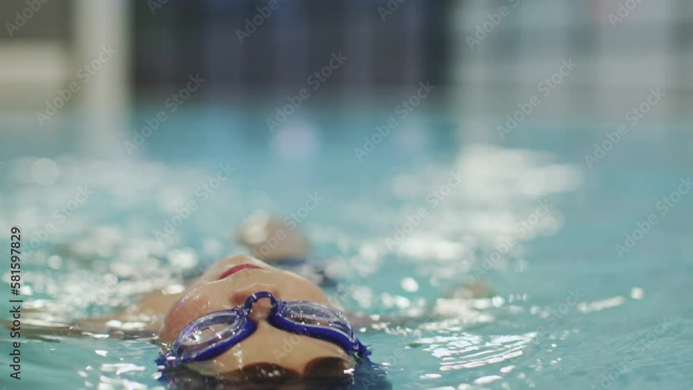 little male boy child swimming on his back during swimming class ...