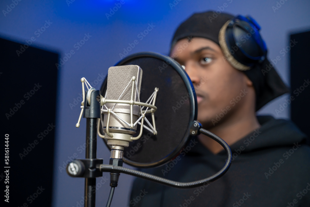 Foto de jeune chanteur derrière un micro de studio d'enregistrement do ...
