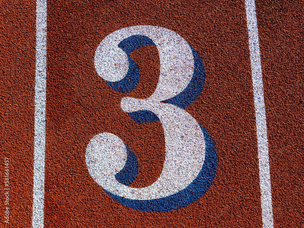 Close up lane number 3 on a new red running track with white lane lines ...