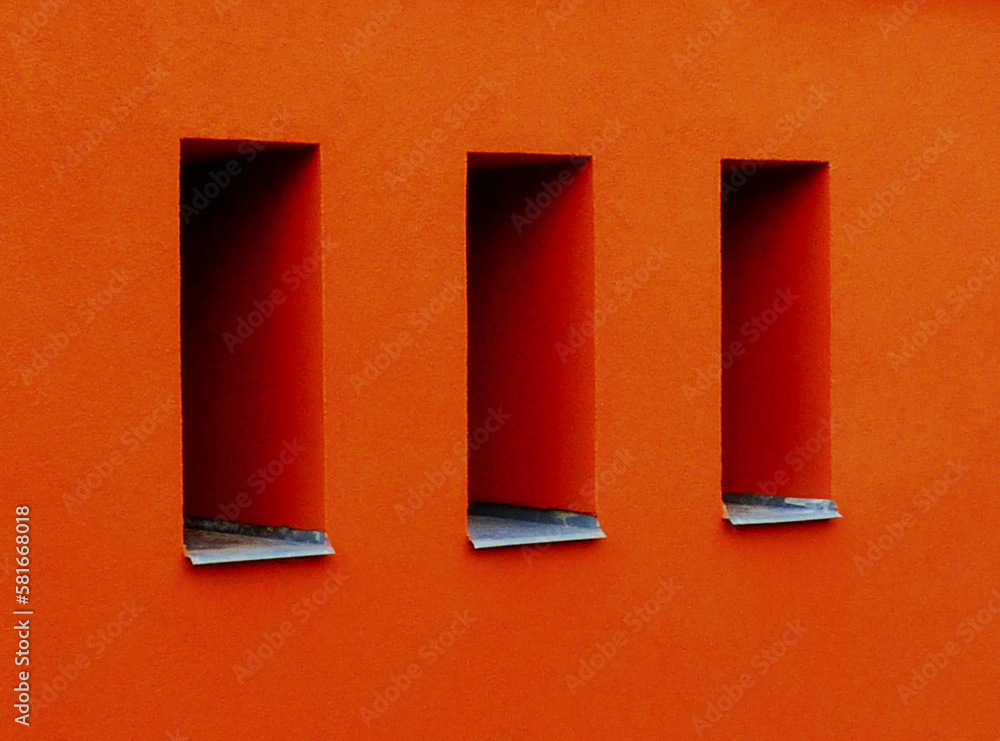 orange stucco exterior wall elevation detail with small narrow punched ...