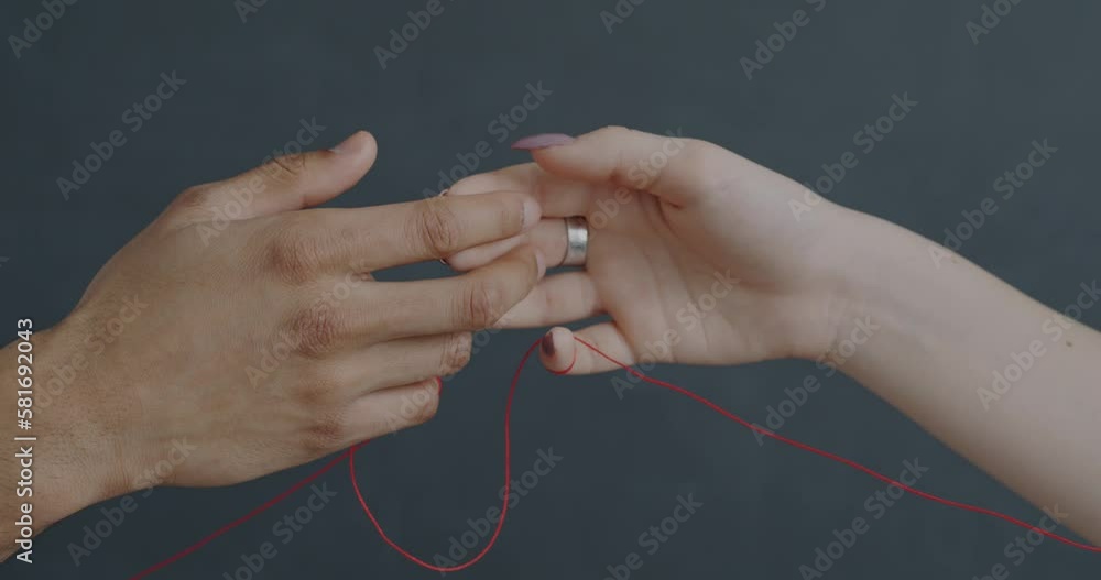 Two hands tied with red string touching fingers expressing love ...