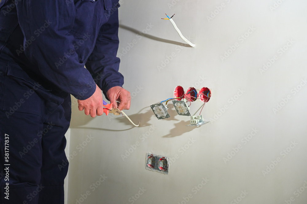 Professional electrician technician installing a wall socket in a new ...