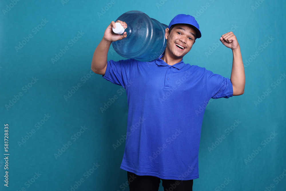Deliveryman in blue uniform carrying a water gallon and showing a ...