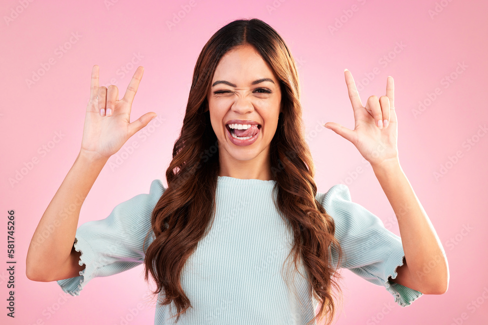Portrait of woman, rock hand gesture and wink in studio, heavy metal ...