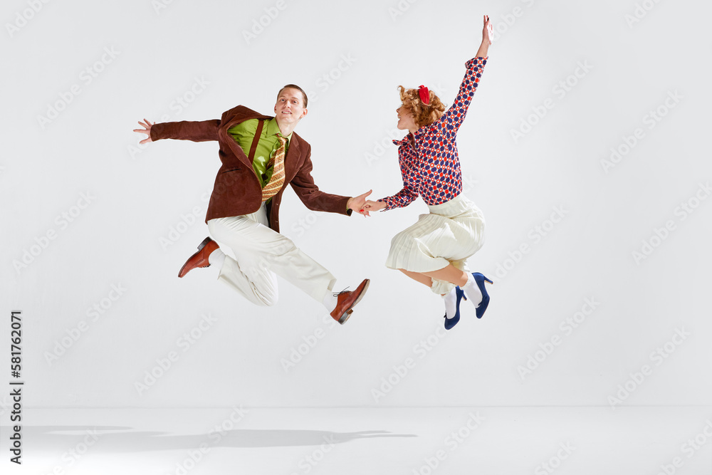Jumping high and having fun. Young man and woman in stylish clothes ...