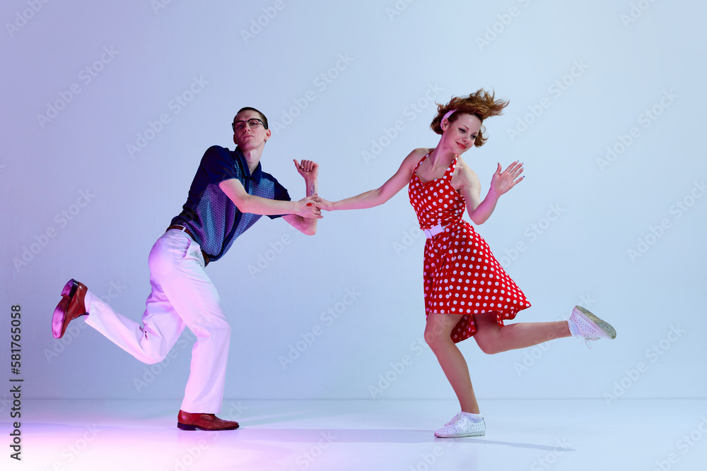 Active delightful young man and woman in colorful costumes dancing ...