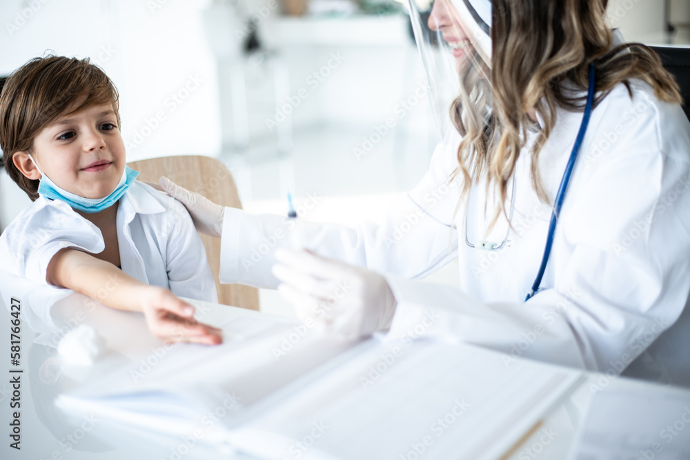 Nurse calming the little patient down and patting him on the back as ...