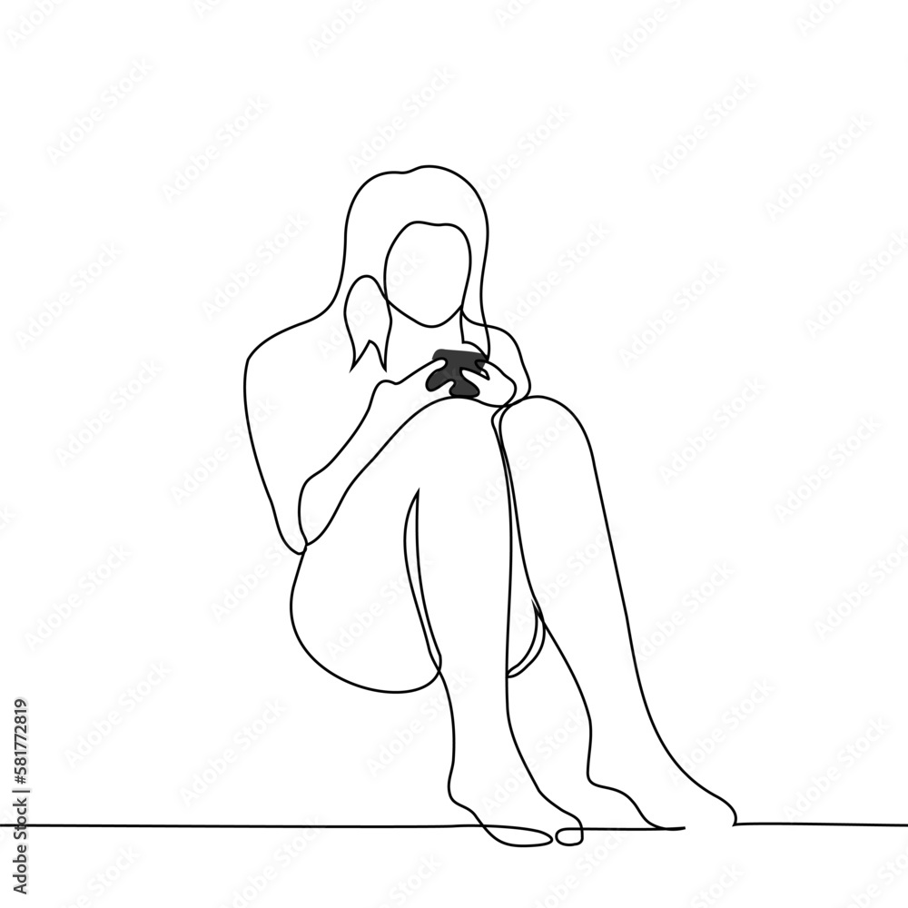 woman sitting leaning back against the wall holding phone with both ...