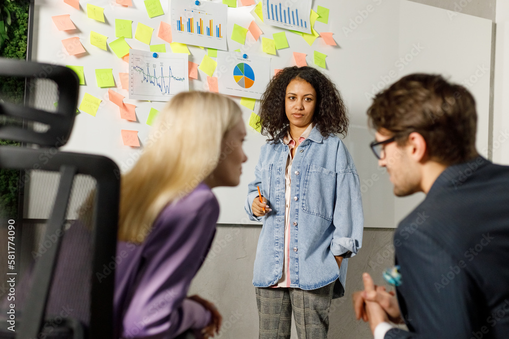 Busy diverse business team working on project together, talking ...