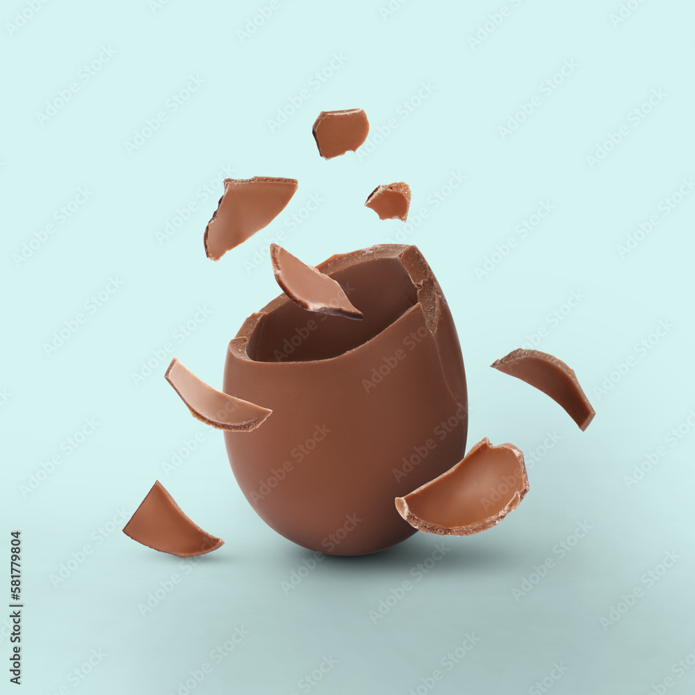 Exploded milk chocolate egg on dusty light blue background Stock Photo ...
