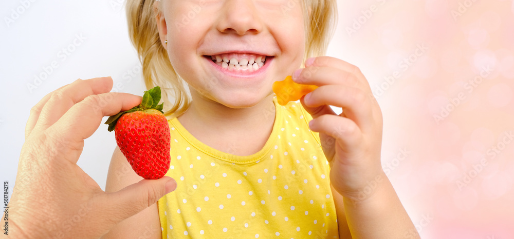cheerful small child holds sweets, blonde girl 3 years old wants eat ...