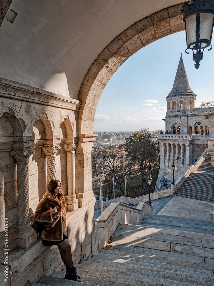 Vertical of a young woman standing on steps at Fisherman's bastion in ...