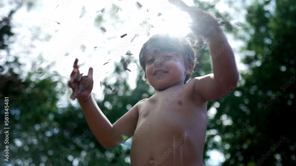 Cute shirtless little boy playing outside smiling at camera standing at ...