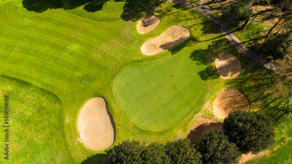 Aerial perpendicular view of an empty golf course with green hills and ...