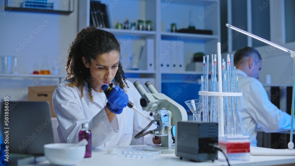 Chemical lab worker adding a drop of cosmetic sample at test glass ...