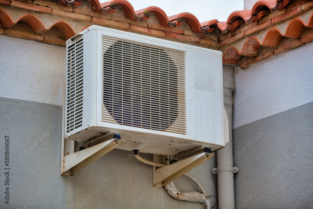 Exterior view of split air conditioner unit installed on house wall ...