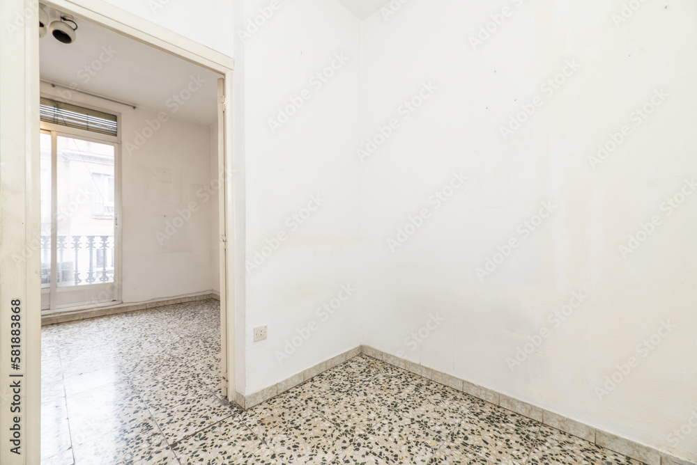 Small empty room of a house with terrazzo floors with black dots and ...
