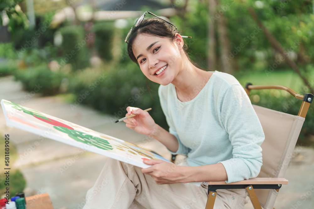 Young asian woman artist painting on canvas..Female artist drawing with ...