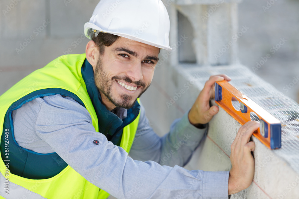 happy man sits outdoors with a building level Stock Photo | Adobe Stock
