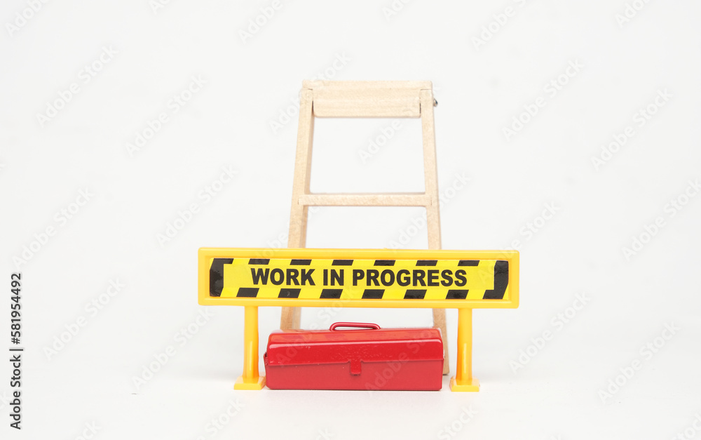 A picture of work in progress sign, tool box and ladder with hammer ...