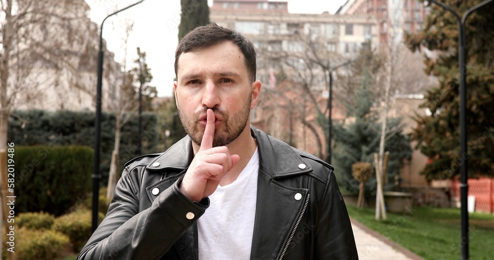 Shh, be quiet. Portrait of bearded man making silence gesture with ...
