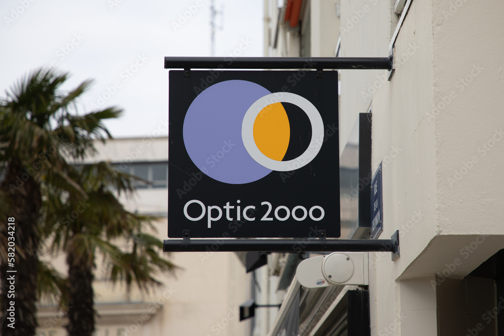 Optic 2000 logo and round sign text on black background on store street ...