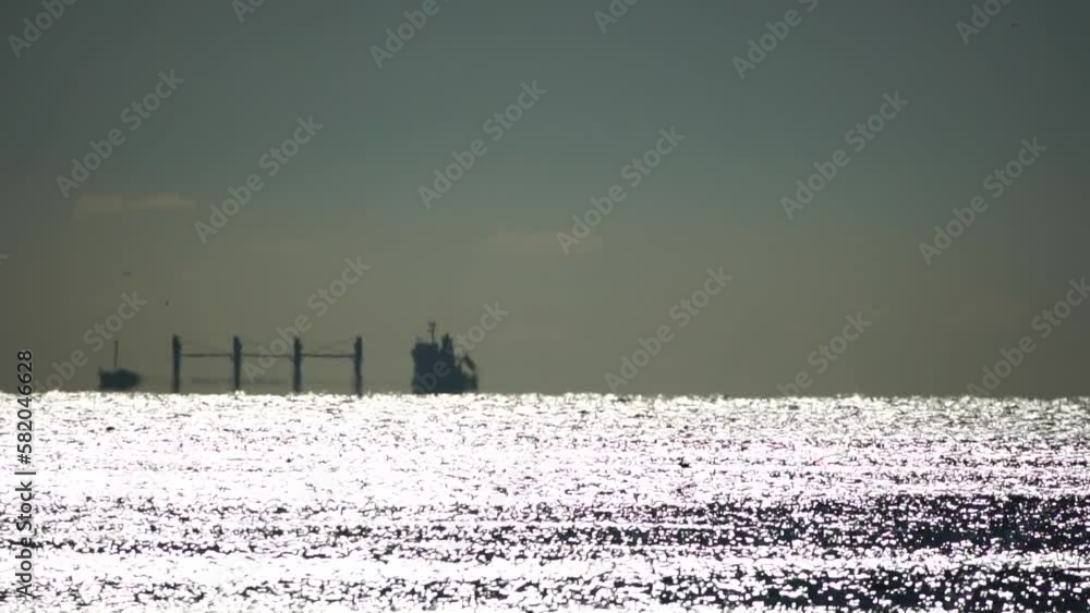 Mirage of cargo ship in the sea beyond the horizon. Fishing ship ...