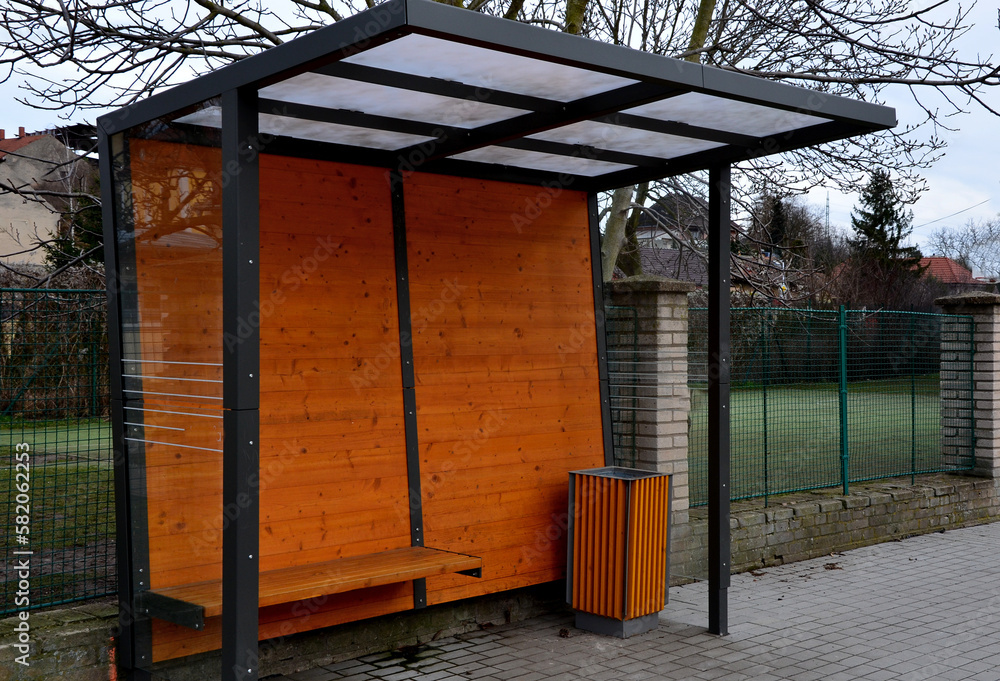 city bus stop. glass shelter with integrated wooden bench. only the ...