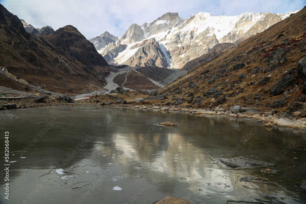 Snow covered peak and a lake in high altitude of Himalaya. Dotted with ...