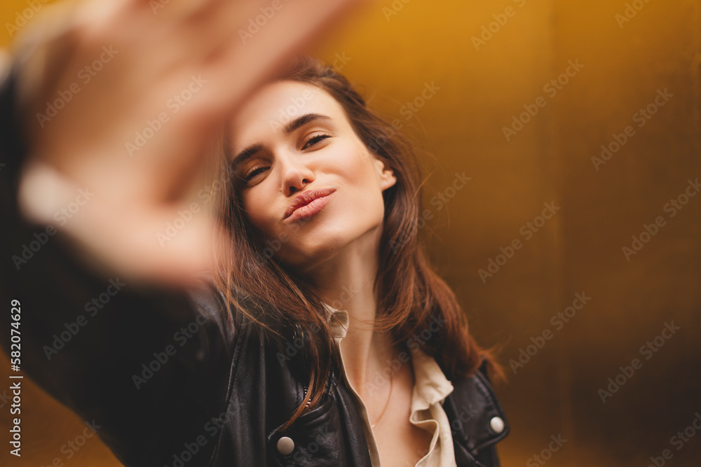 Beautiful smiling model in casual clothes. Sexy carefree female posing isolated on gold ...