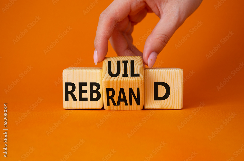 Rebuild and Rebrand symbol. Businessman hand turns wooden cubes and ...