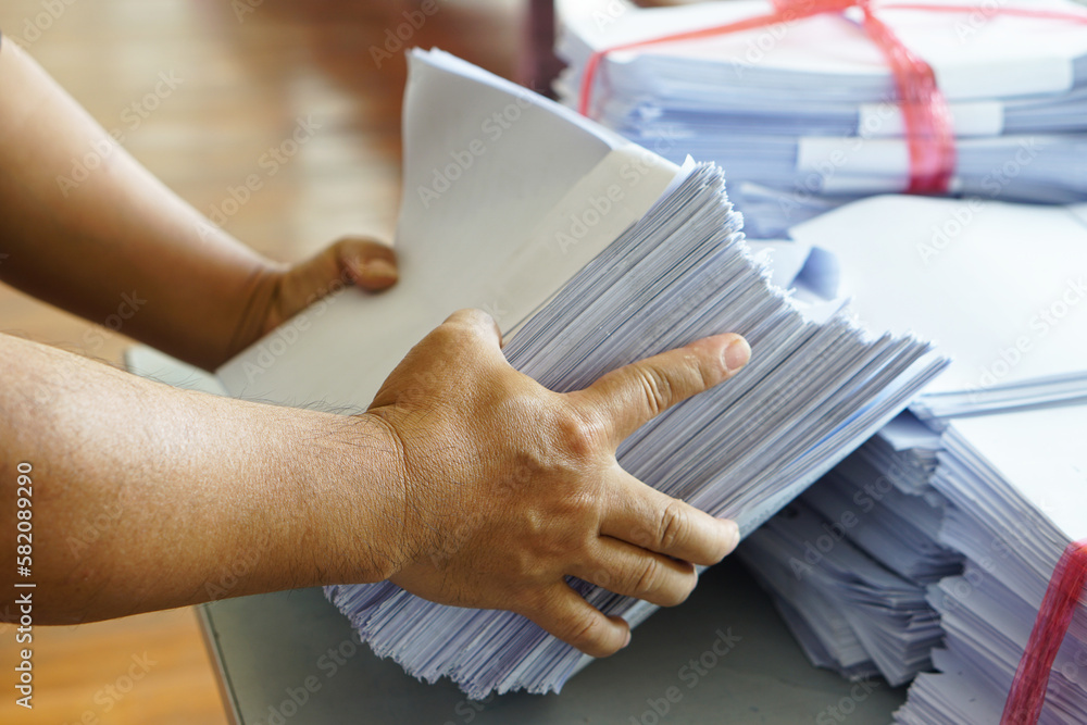 Closeup hands hold stack of used paper to recycle or combine to use ...