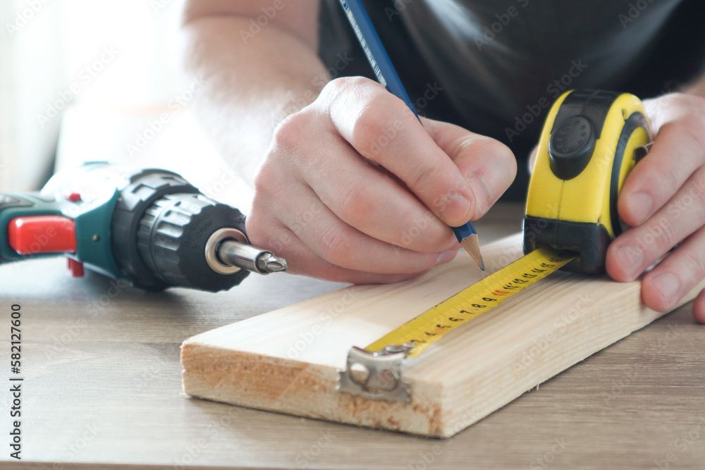Carpenter hand measuring tape with pen in construction site. Making ...