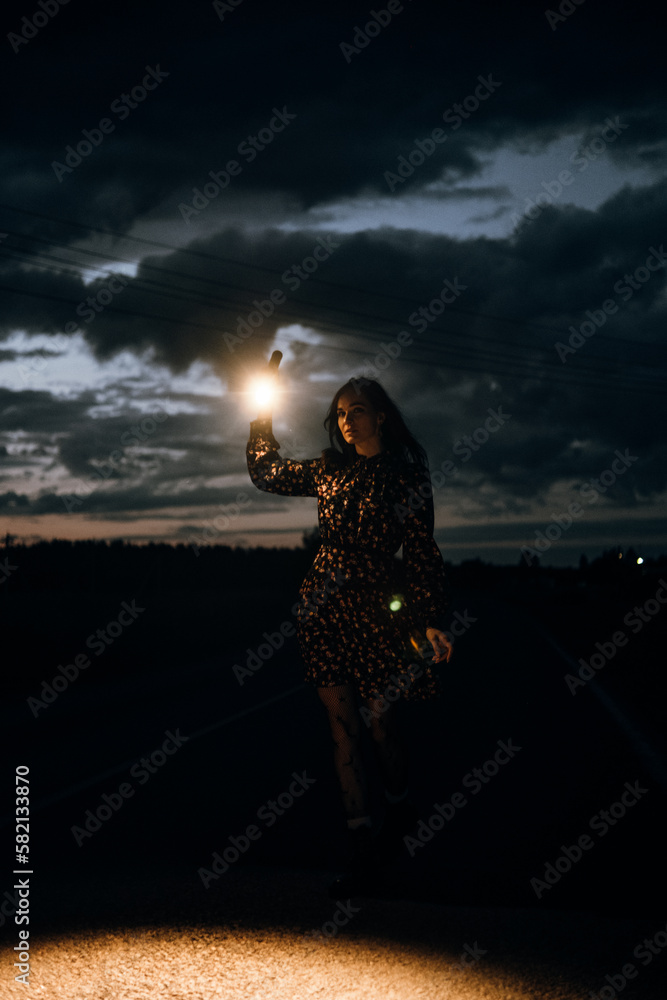 A girl with a lantern in a dress walks along the road at night Stock ...