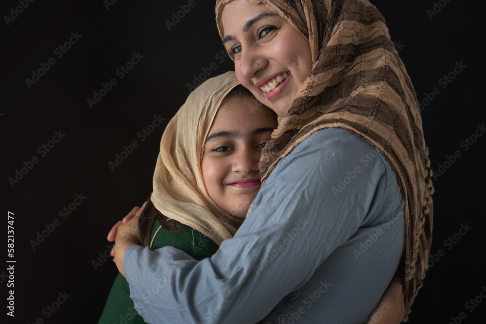 Closeup, Muslim Mother in traditional costume hugging her daughter on ...