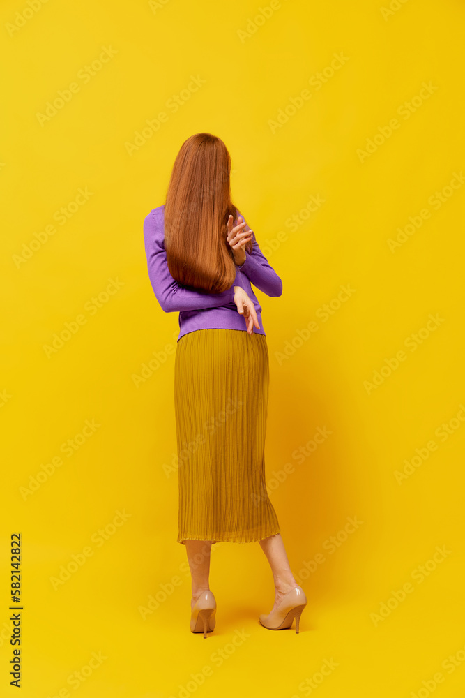 Faceless portrait of slim woman with long straight red hair wearing ...